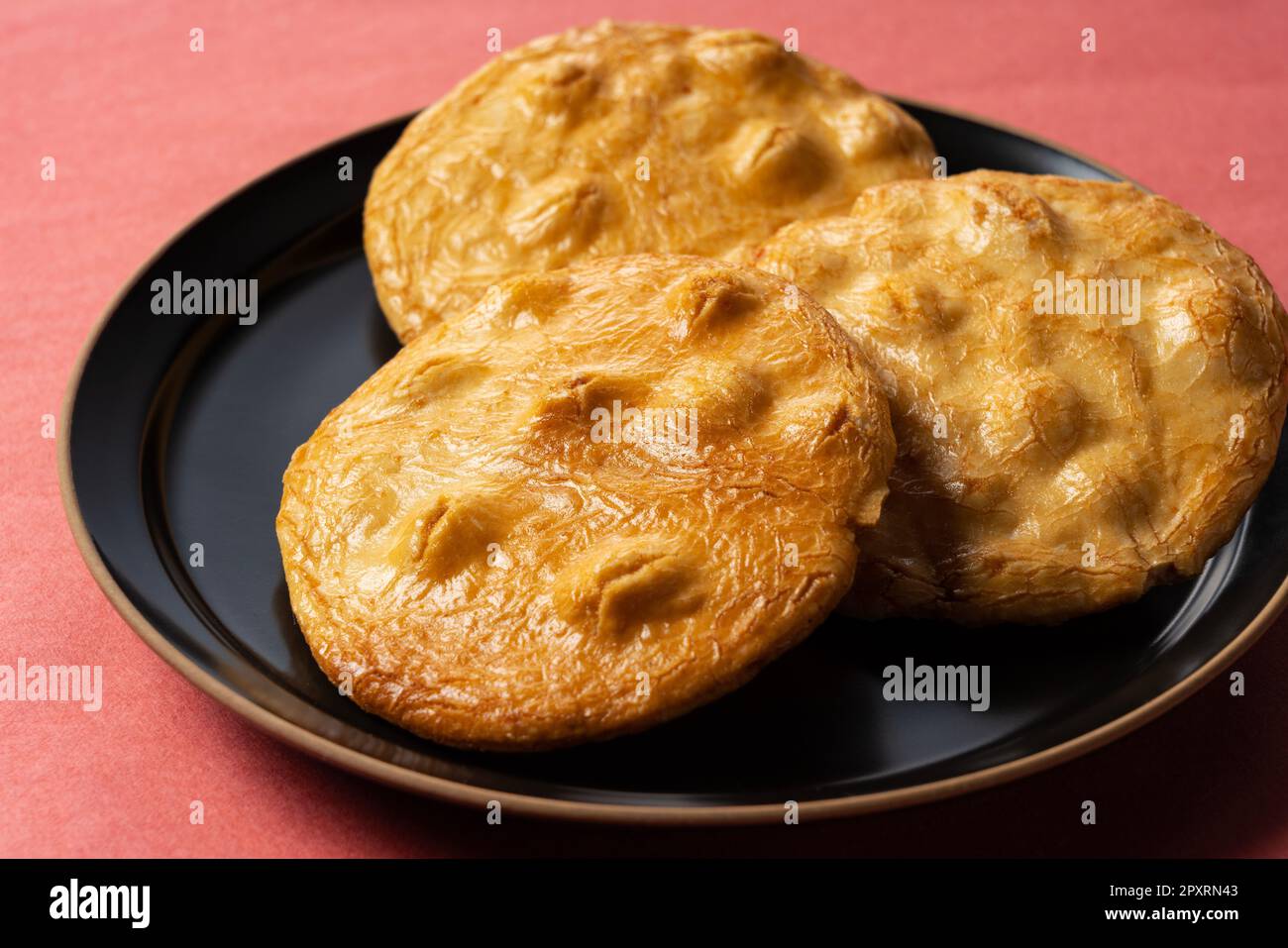 Sembei placed on pink Japanese paper. Sembei is a Japanese snack. A ...
