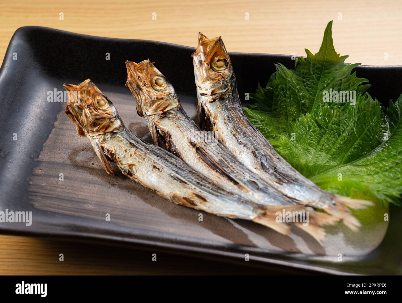 Grilled urume sardine placed on the table. A side dish of sake ...