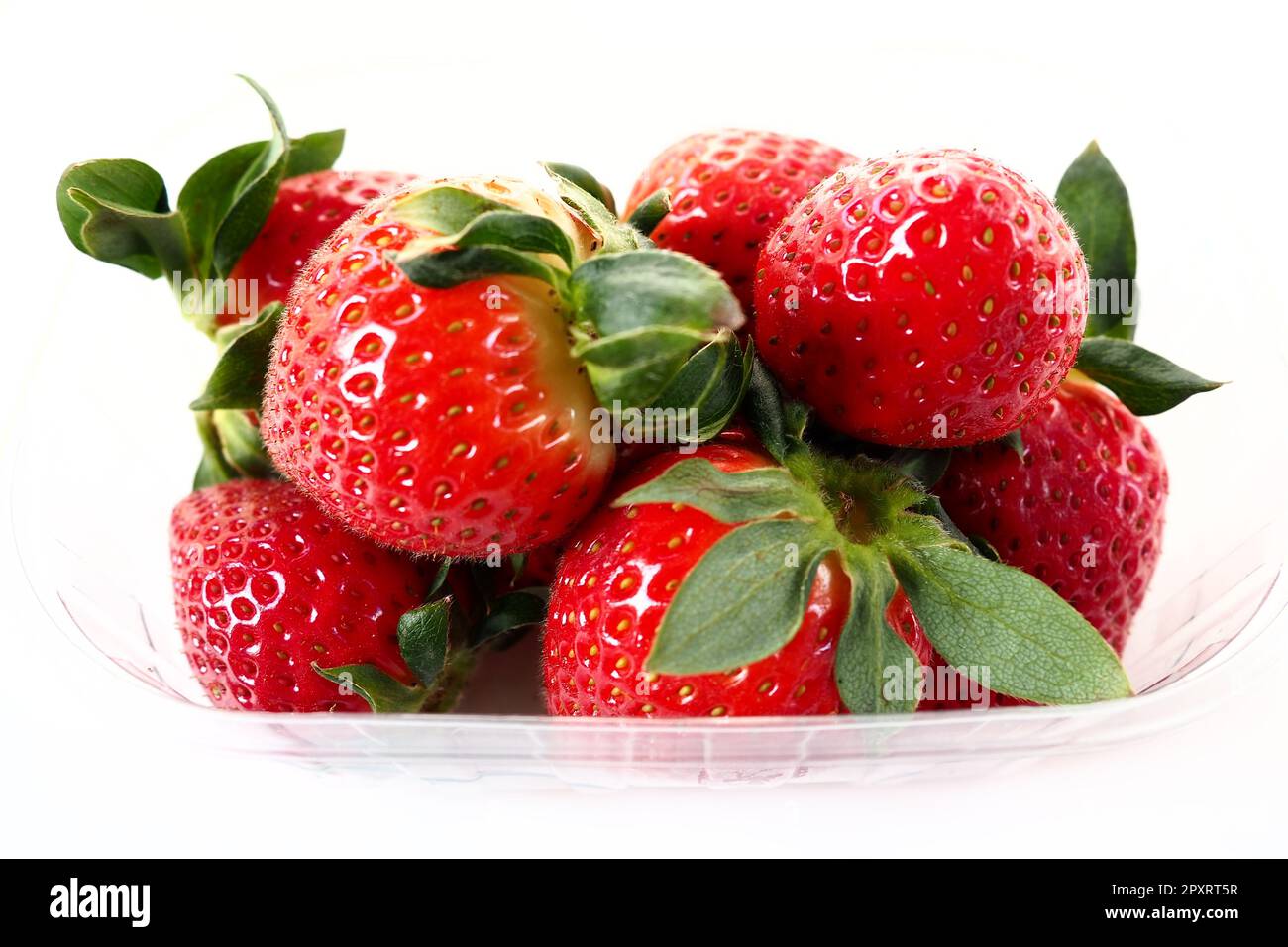 Ripe strawberries in a plastic package on a white background. Delicious ...