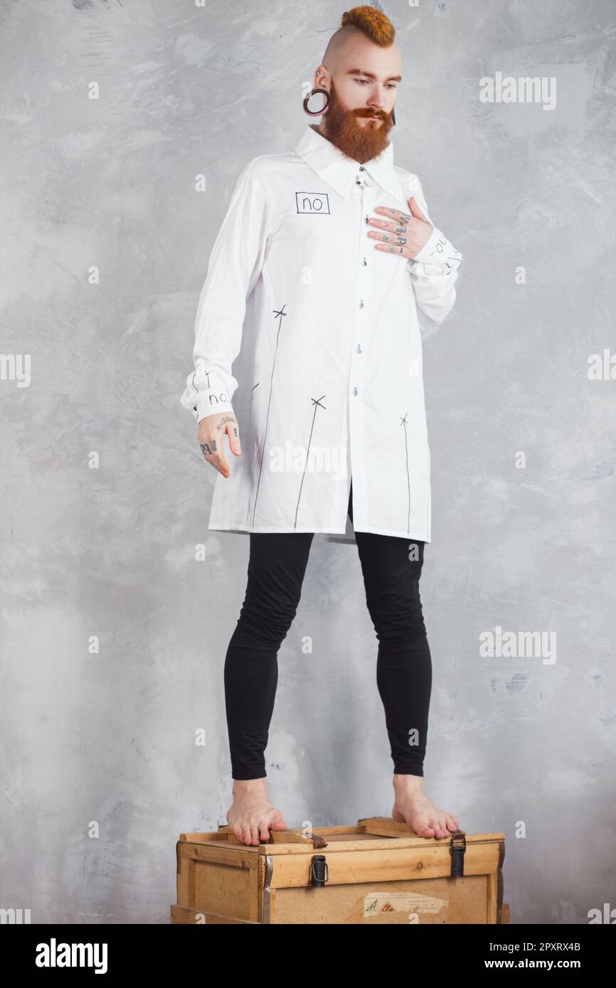 A creative, unusual red-haired man in designer clothes and tunnels in ...