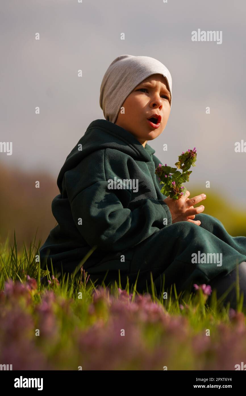 Little boy sitting in a meadow against the sky, view from below Stock ...