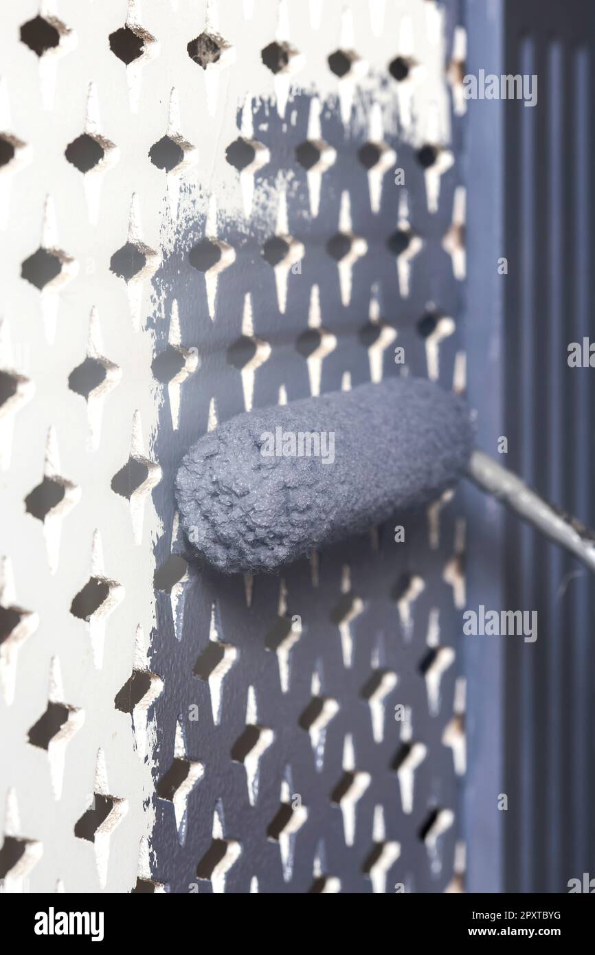 Painting a wooden radiator cover blue using a paint roller. Upcycling ...