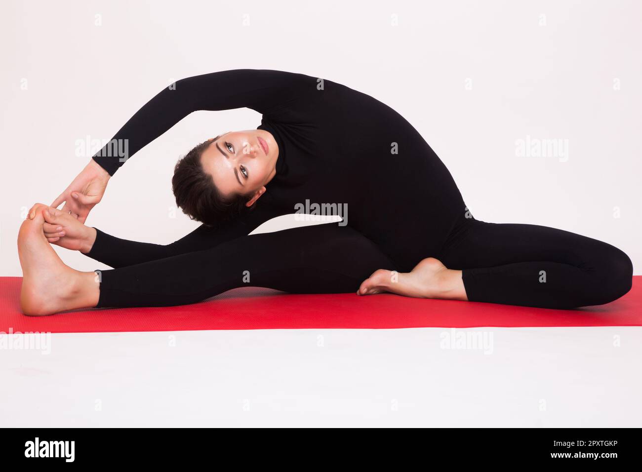 Beautiful athletic girl in black suit doing yoga asanas. Isolated on ...