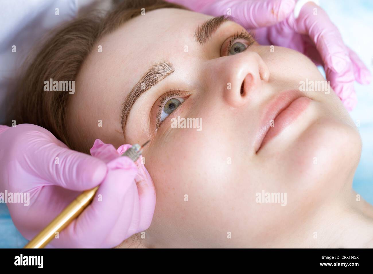 Permanent microblasting tattooing freckles to a woman in a beauty salon ...