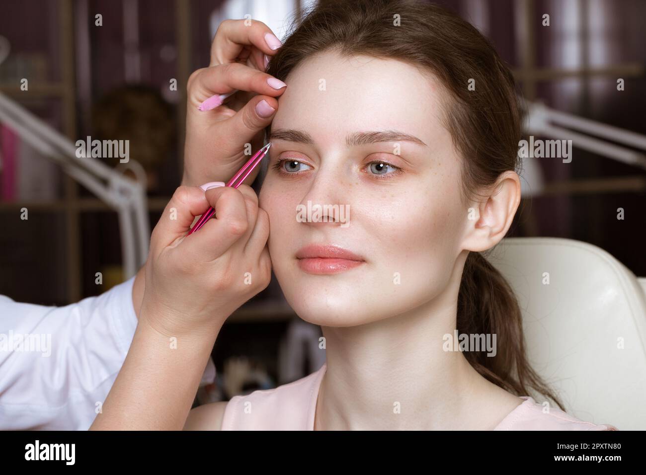 Permanent microblasting tattooing freckles to a woman in a beauty salon ...