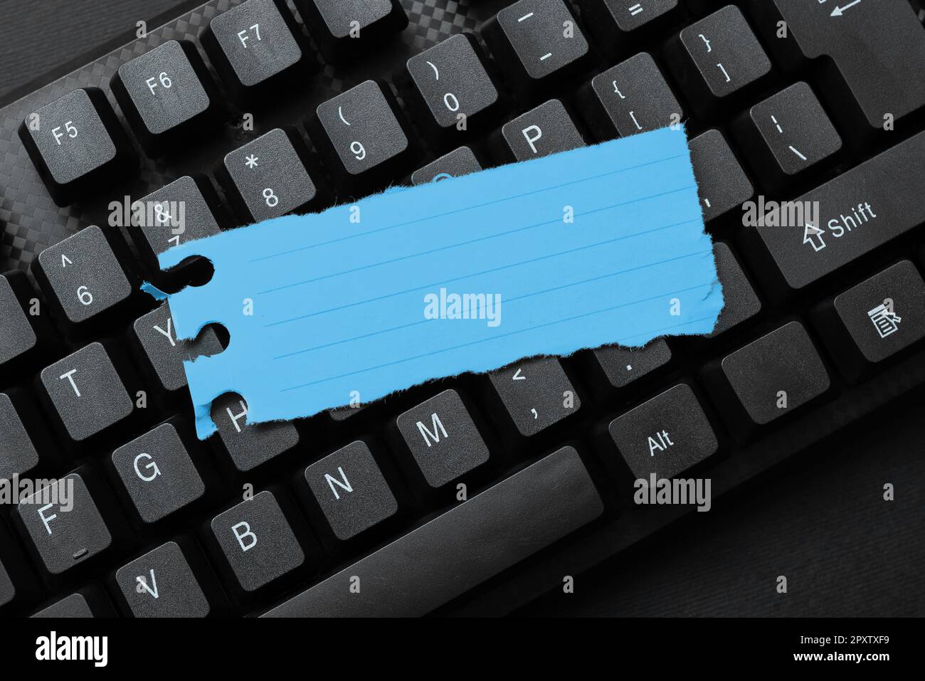 Sticker lying on black keyboard. Important message written over paper ...