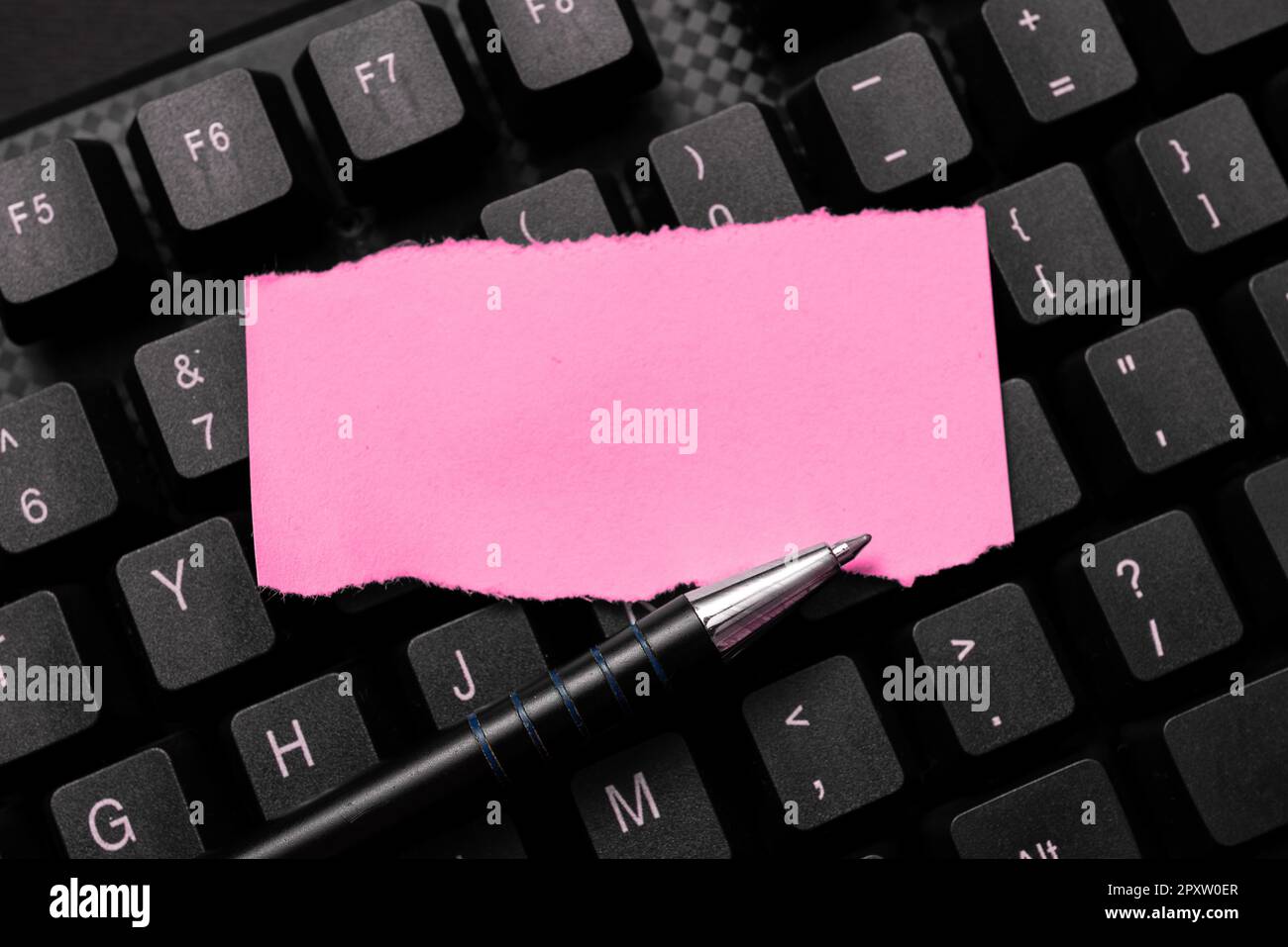 Colored sticker lying on keyboard. Important message written over paper ...