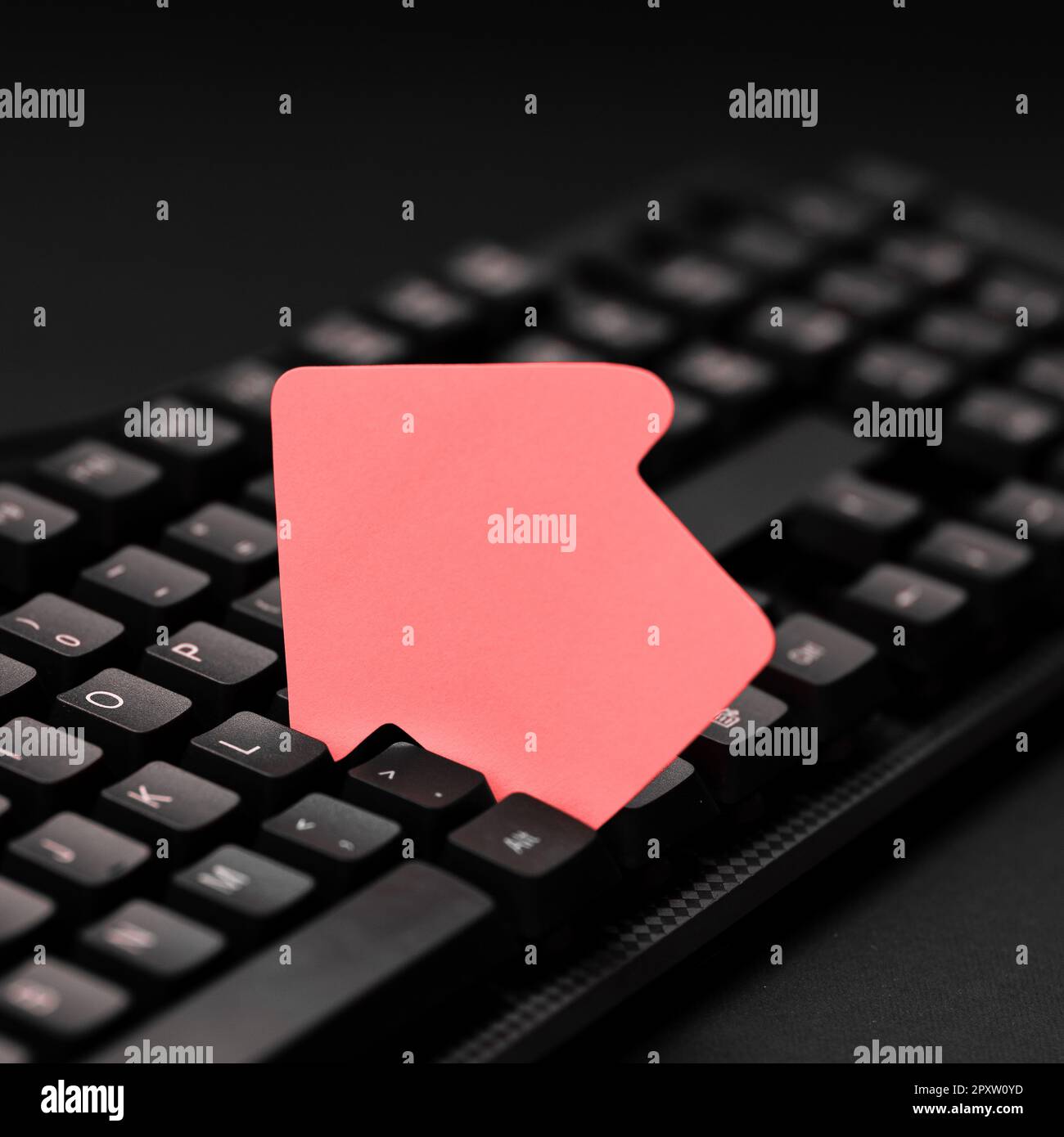 Sticker lying on black keyboard. Important message written over paper ...