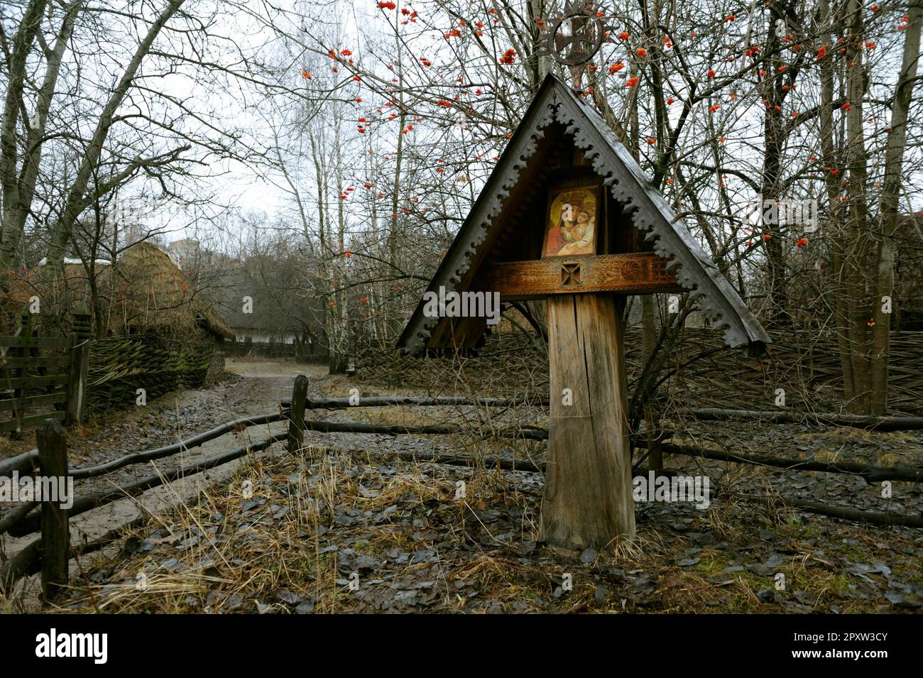 Typical Ukrainian rural street, wooden cross and icon of Christ set on ...