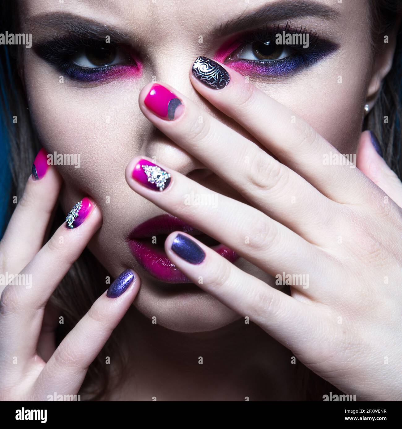 Beautiful girl with bright creative fashion makeup and colorful nail ...