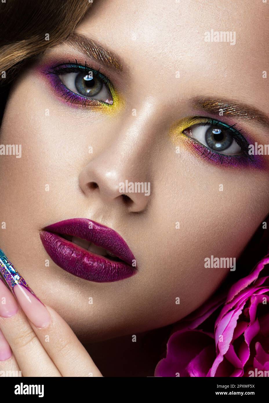 Beautiful girl with colorful make-up, flowers. The beauty of the face ...
