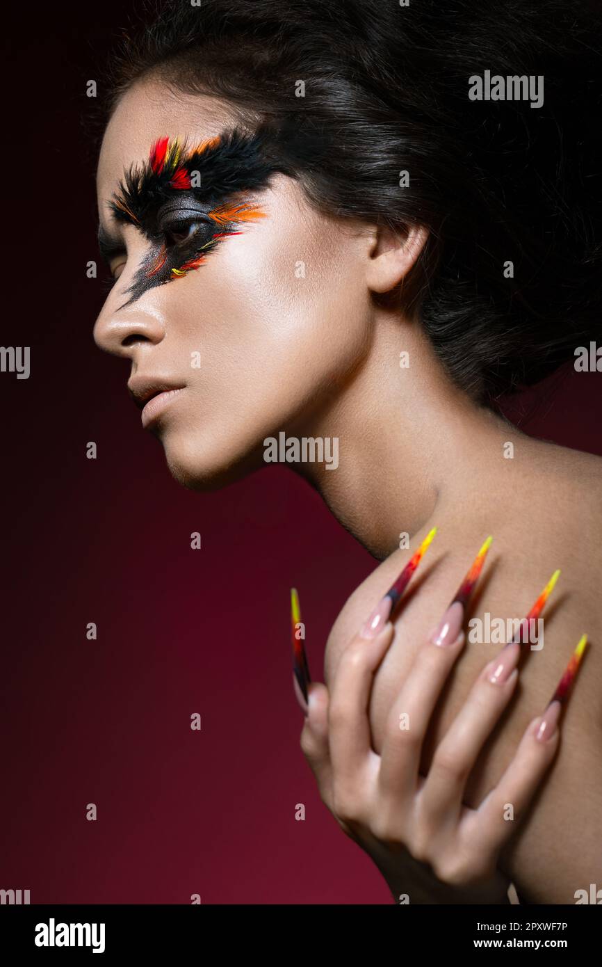 Beautiful girl in the image of the Phoenix bird with creative makeup ...