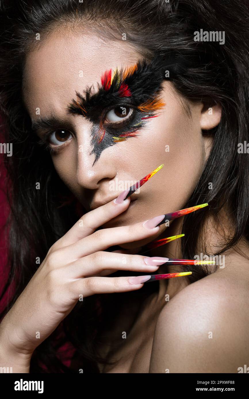 Beautiful girl in the image of the Phoenix bird with creative makeup ...