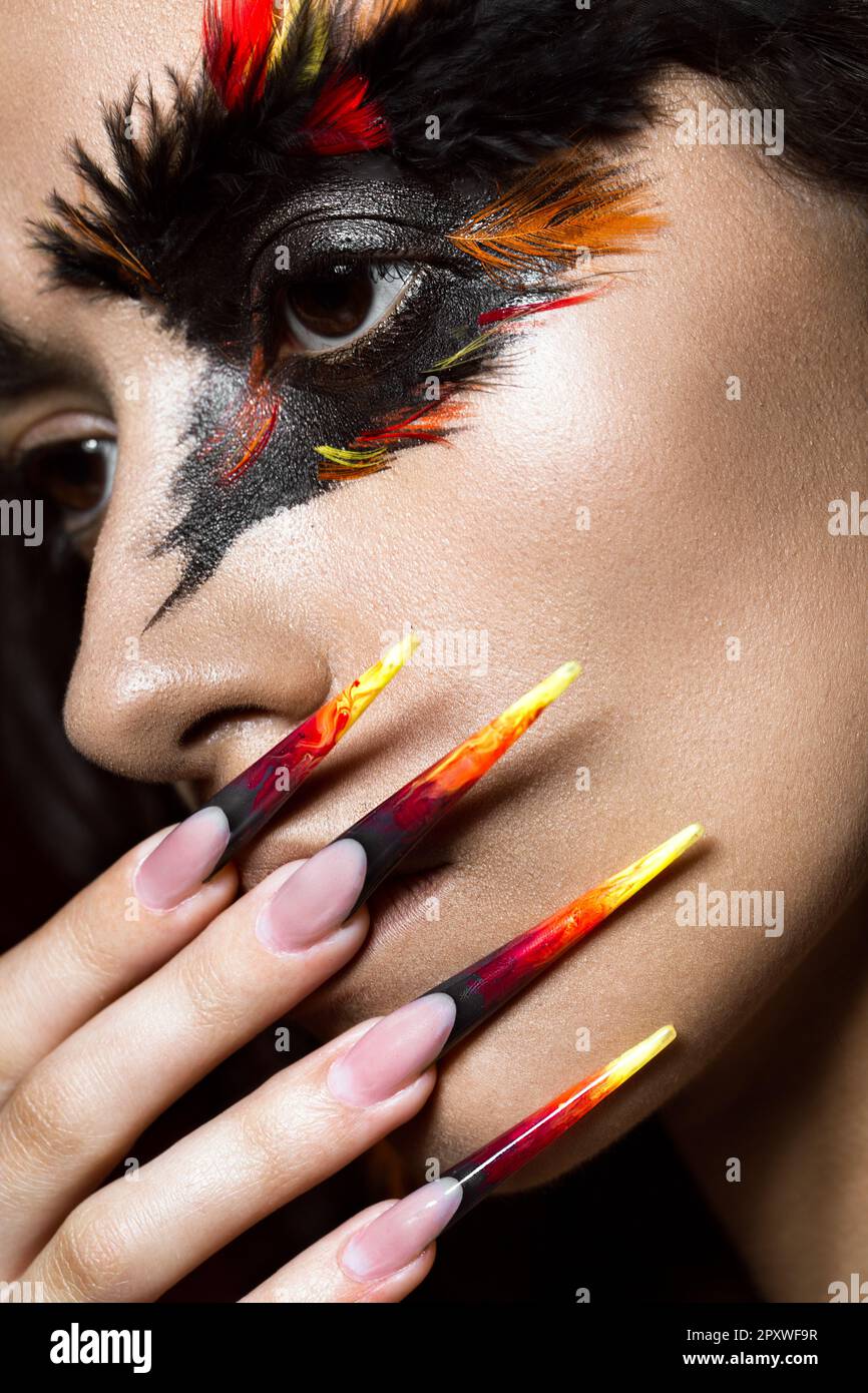 Beautiful girl in the image of the Phoenix bird with creative makeup ...