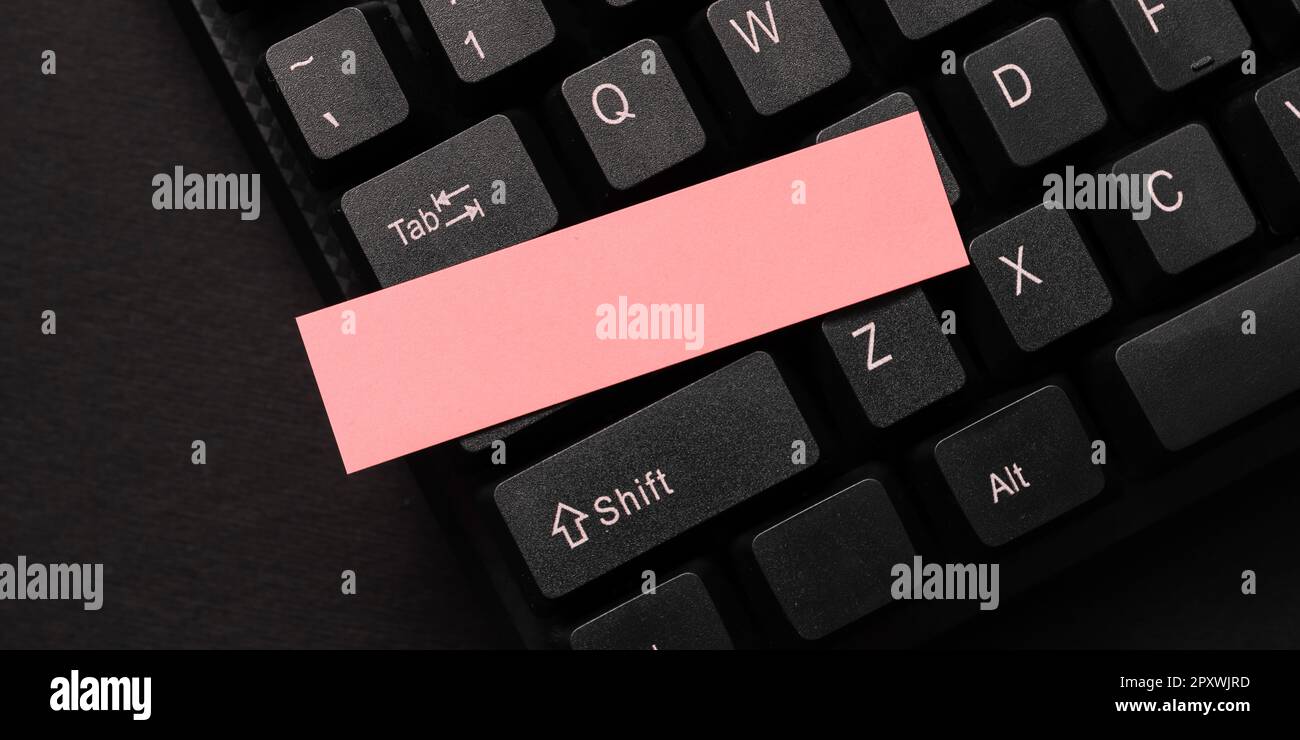 Sticker lying on black keyboard. Important message written over paper ...