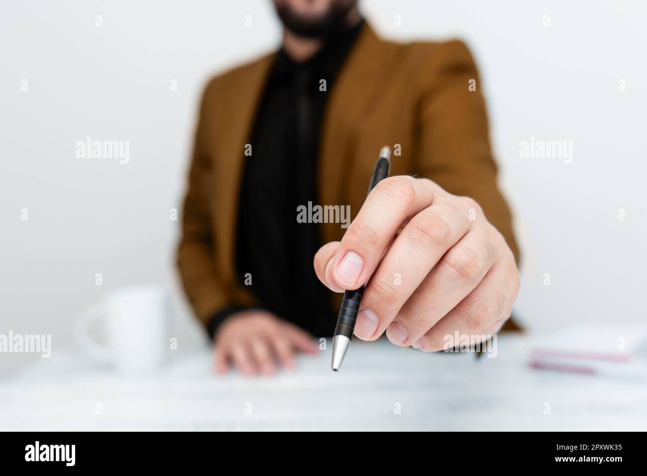 Male mode sitting at table And Pointing With Pen On Important Message ...