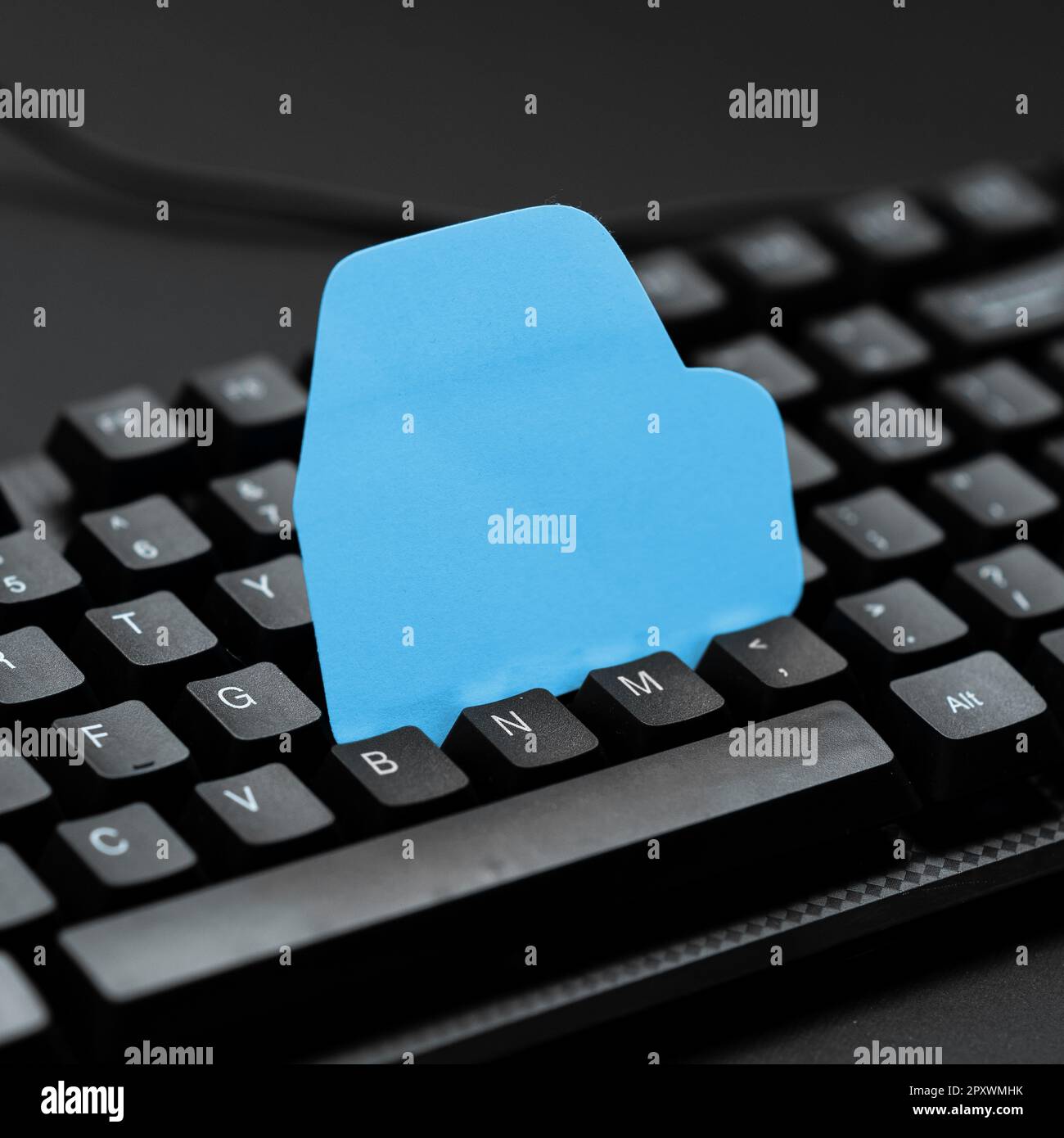 Sticker lying on black keyboard. Important message written over paper ...