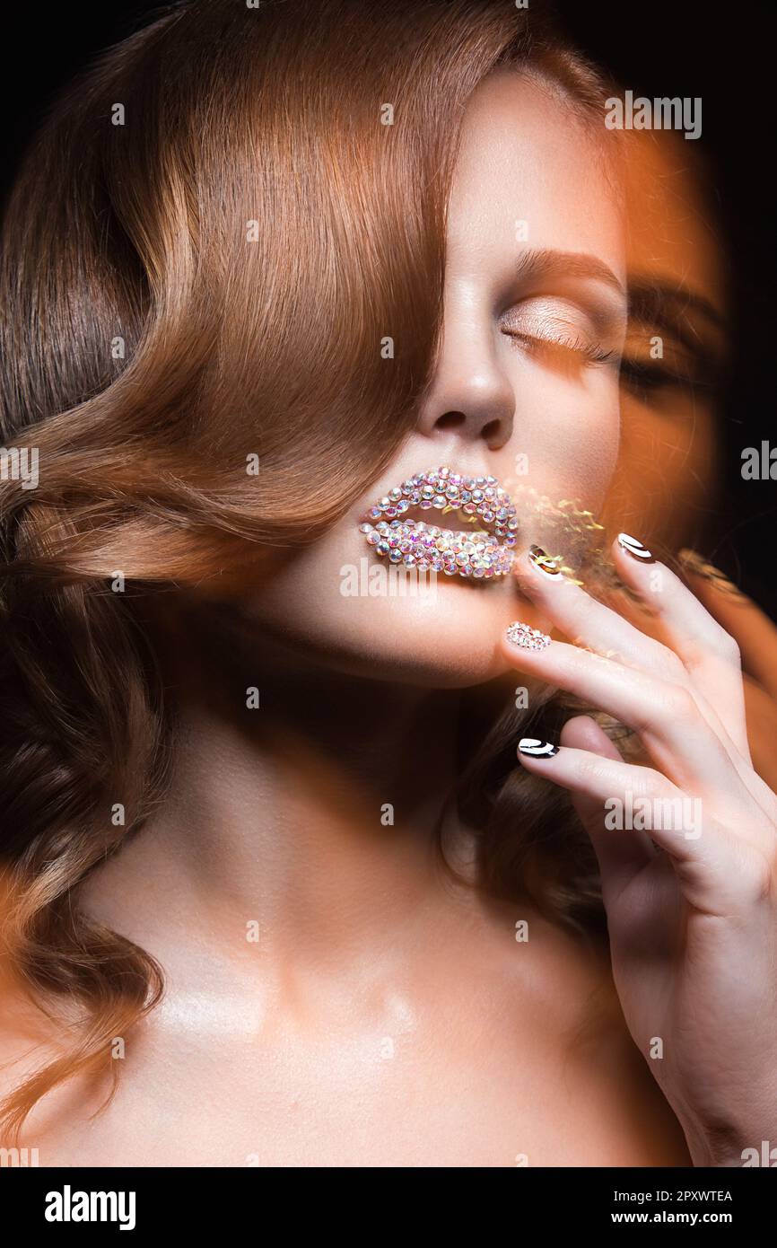 Beautiful girl with bright nails and lips of crystals, long eyelashes ...