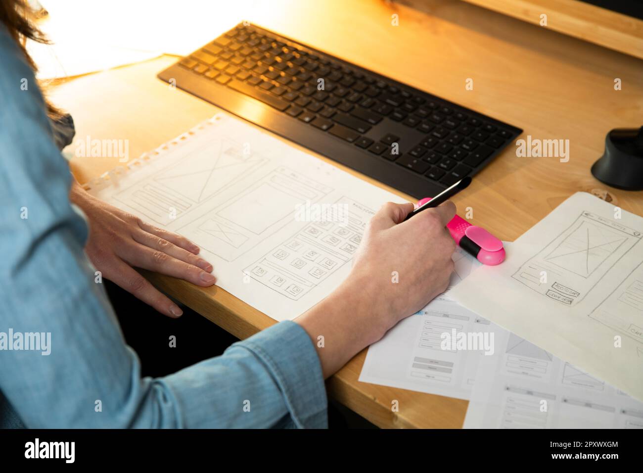 Sketch of wireframe for website. Women designer working on a mobile ...
