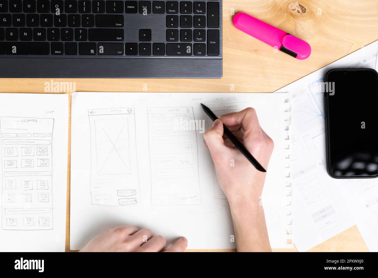 Sketch of wireframe for website. Women designer working on a mobile ...