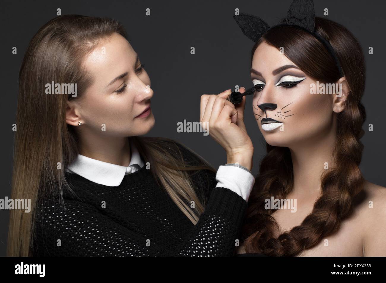 Two beautiful girls on a photo shoot to apply makeup to the face ...