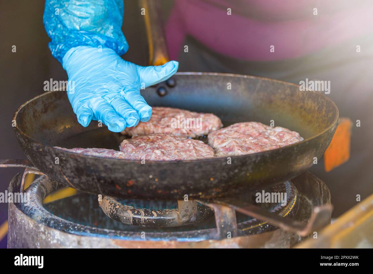 The hands of the cook prepare cutlets from minced pork in a frying pan ...