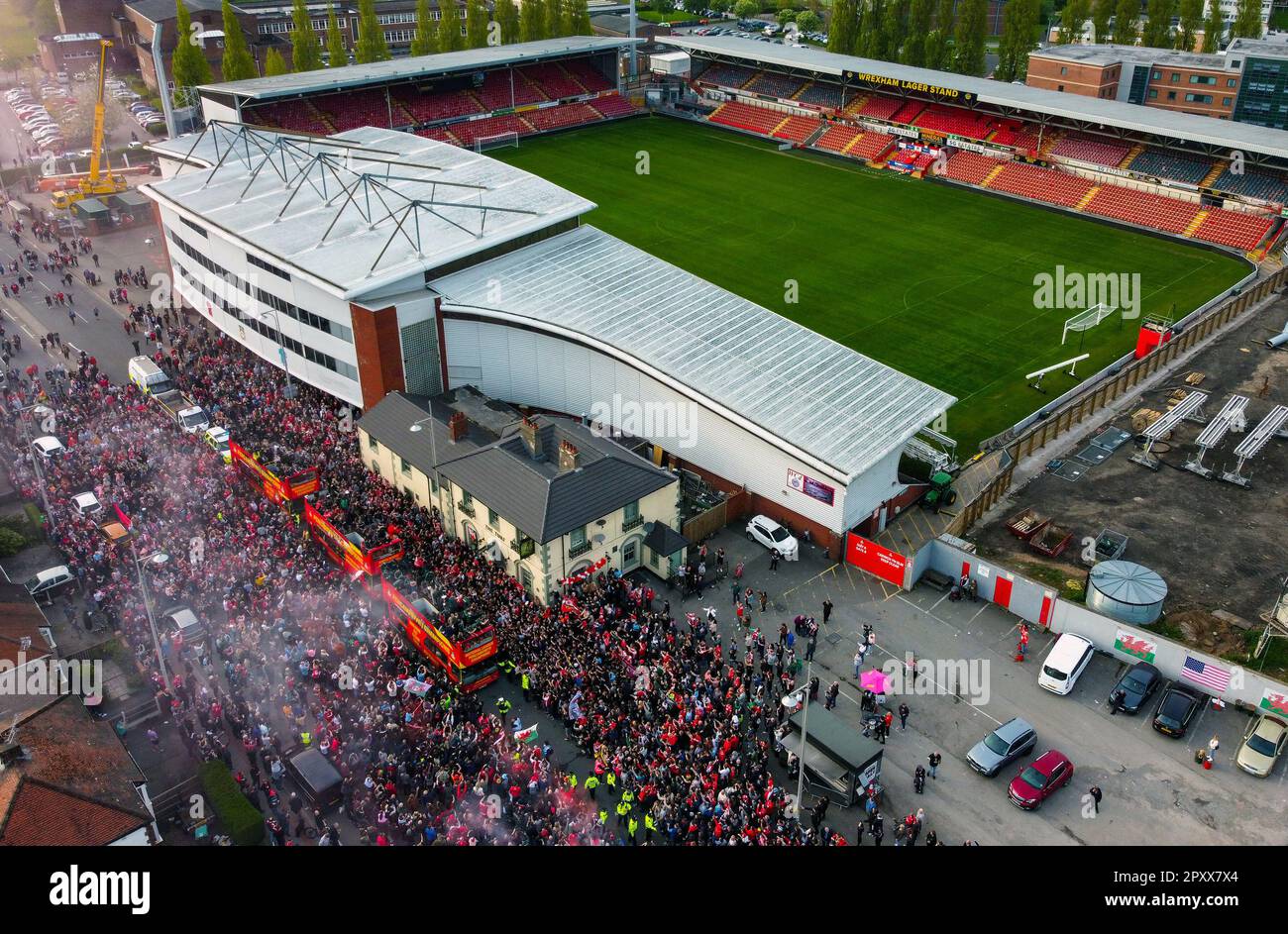 An aerial view of open topped busses carrying Wrexham players passes ...