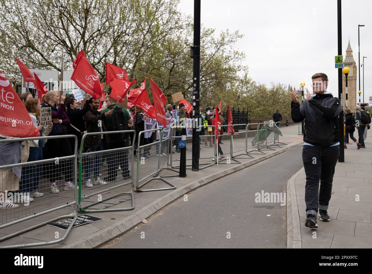 London, UK. 02nd May, 2023. A pedestrian claps his hands to the NHS ...