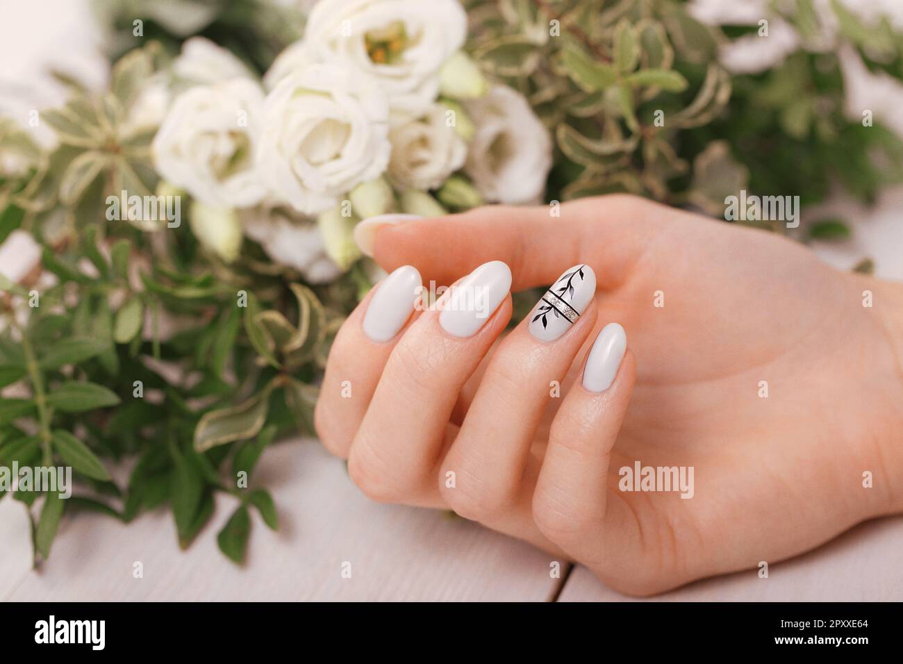 Gentle neat manicure on female hands on a background of flowers. Nail ...