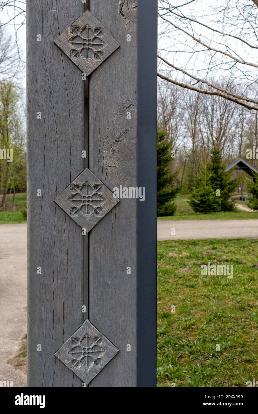 A wooden pole with a metal frame and an ornament carved into the wood ...