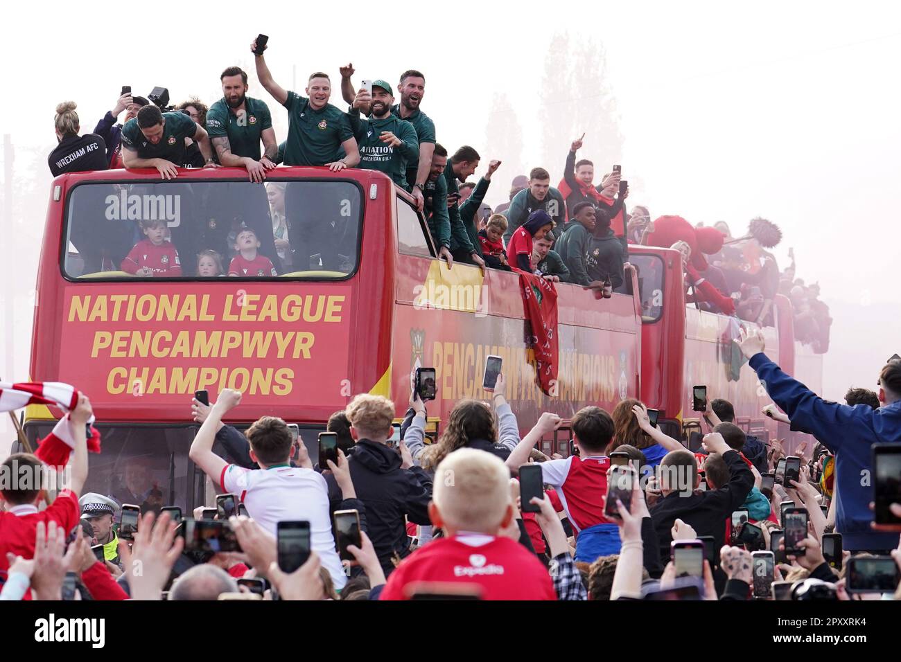 Fans celebrate with players who pass through the crowds on an open top ...