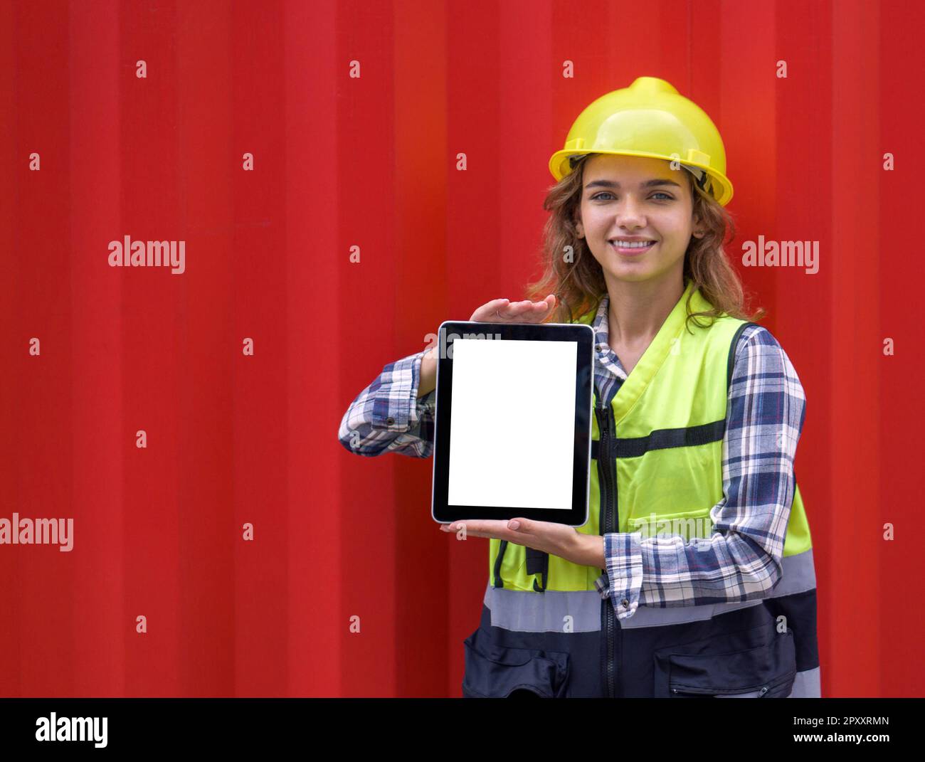 Young caucasian woman with safety vest and yellow hardhat holding white ...