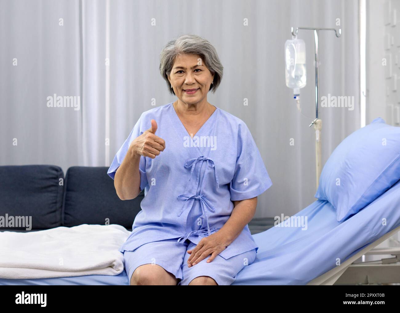 Elderly female patient raise finger thumbs up with a smile while ...