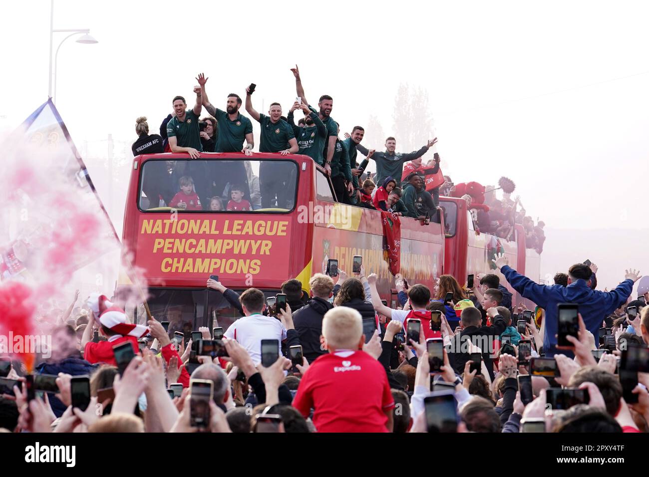 Fans celebrate with players who pass through the crowds on an open top ...