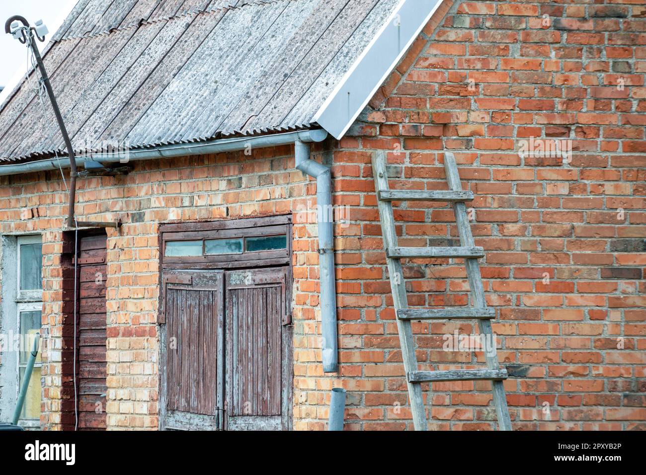 A brick wall with a ladder leaning against it Stock Photo - Alamy