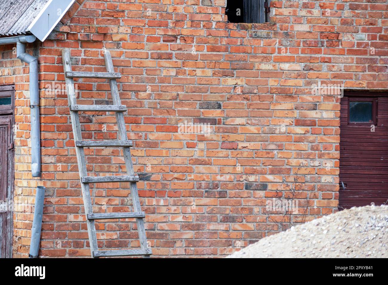 A brick wall with a ladder leaning against it Stock Photo - Alamy