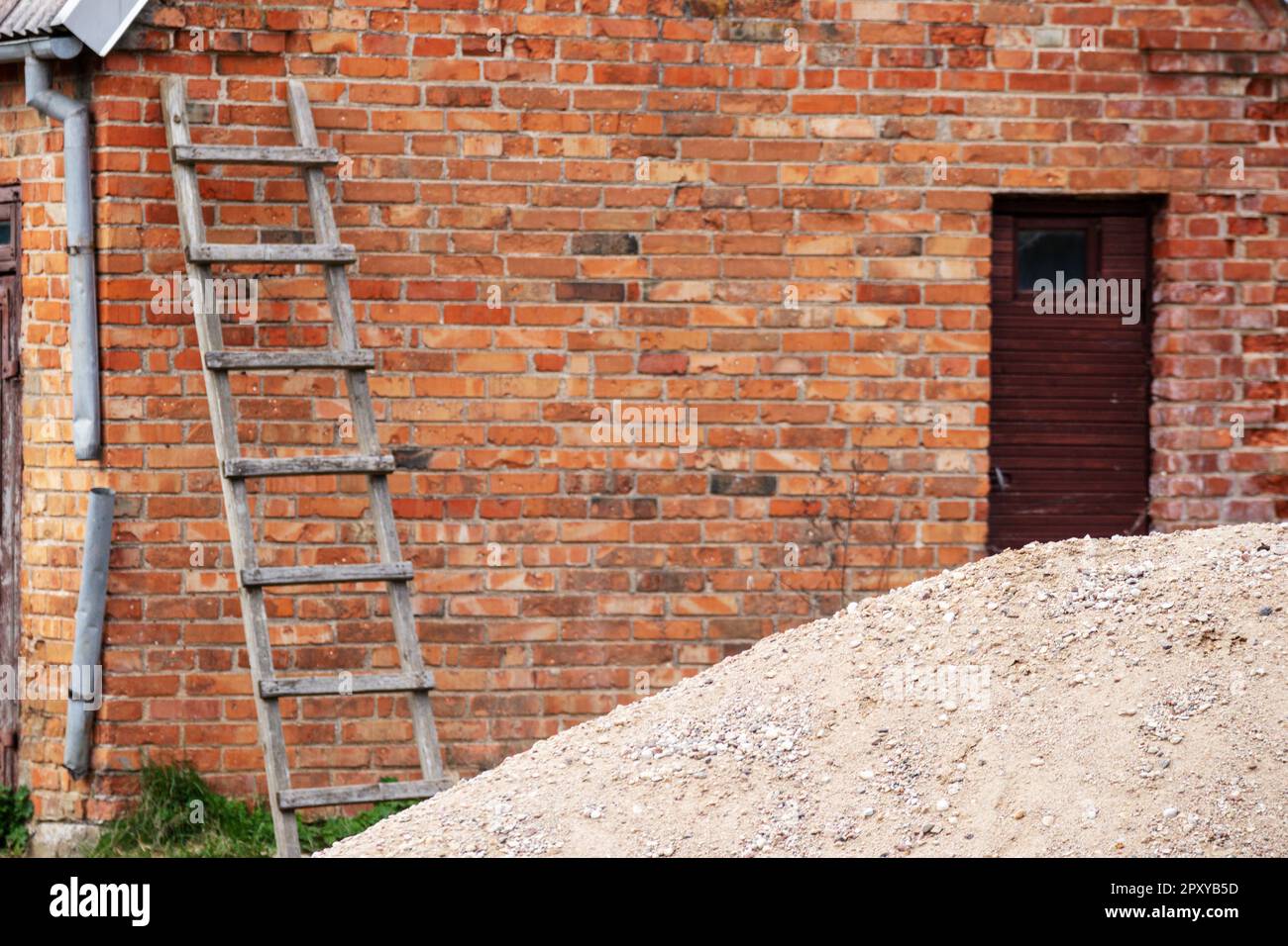 A brick wall with a ladder leaning against it Stock Photo - Alamy