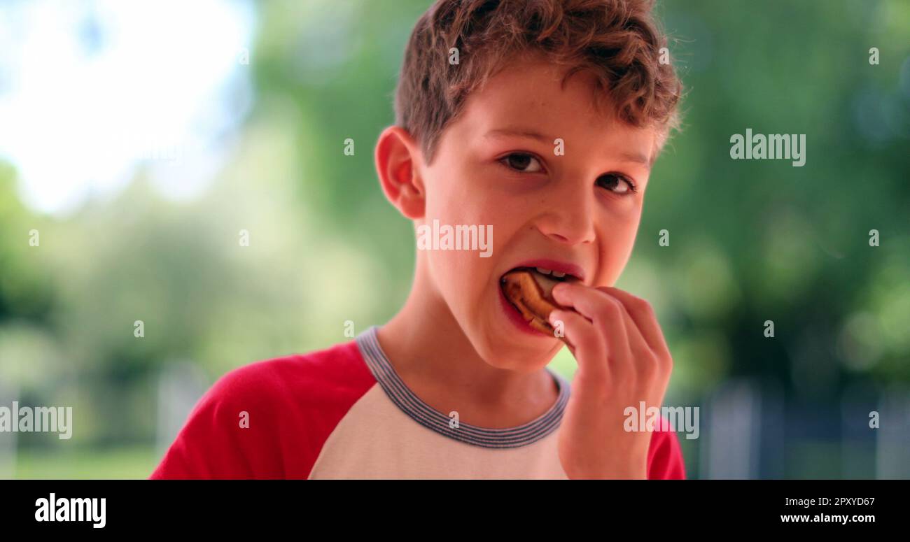 Child taking a bite of sandwich Stock Photo - Alamy