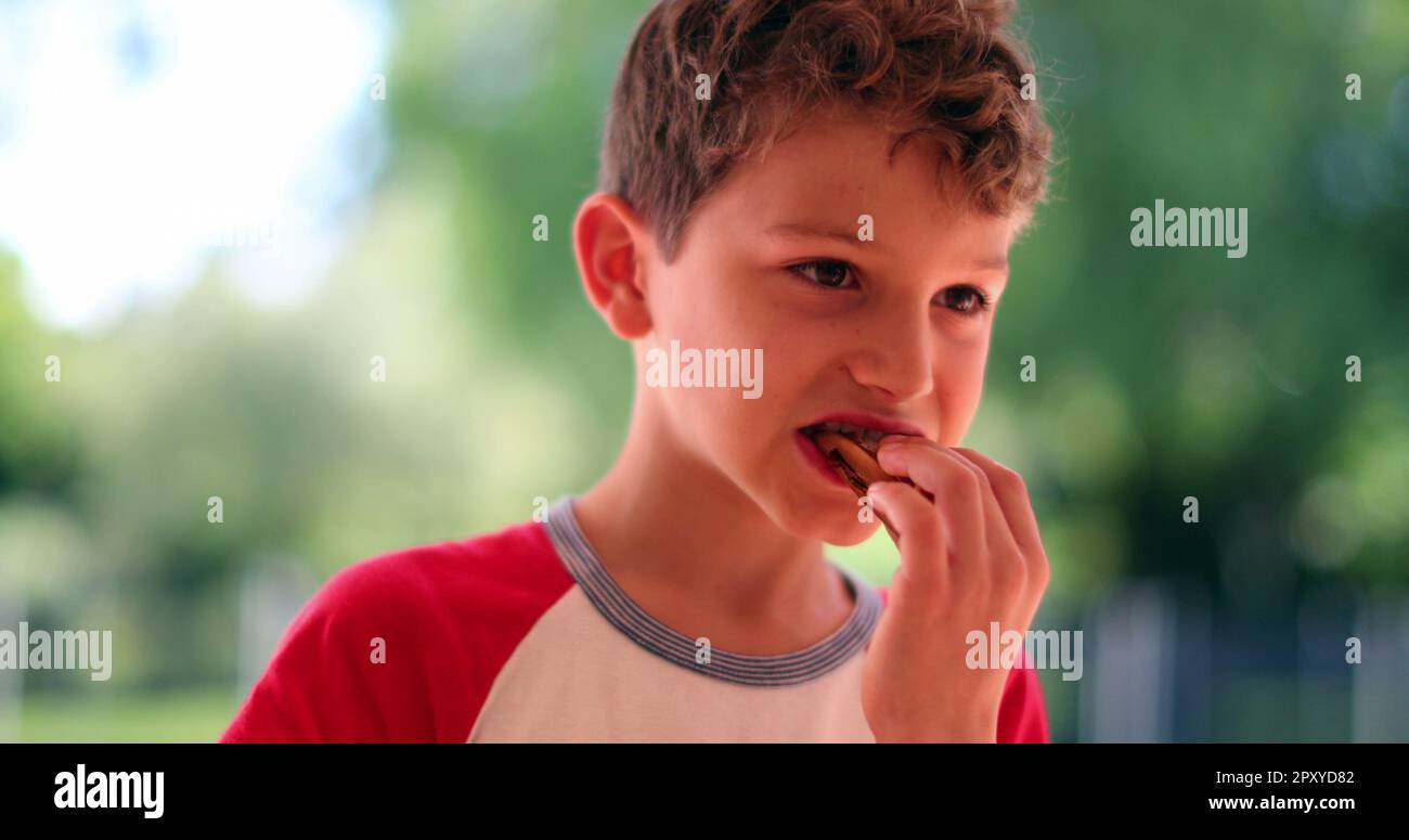 Child taking a bite of sandwich Stock Photo - Alamy