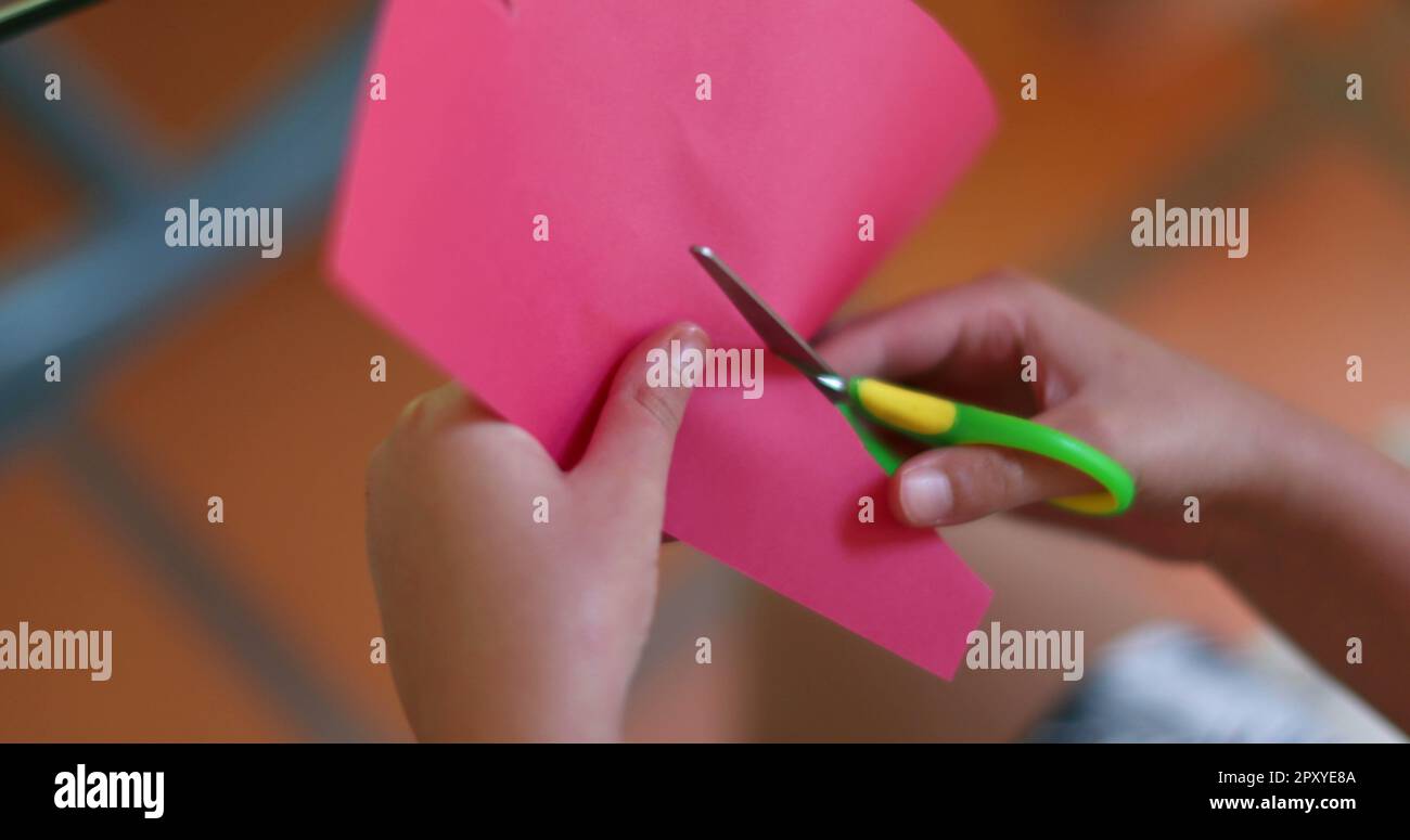 Child hands cutting paper with scissors Stock Photo - Alamy