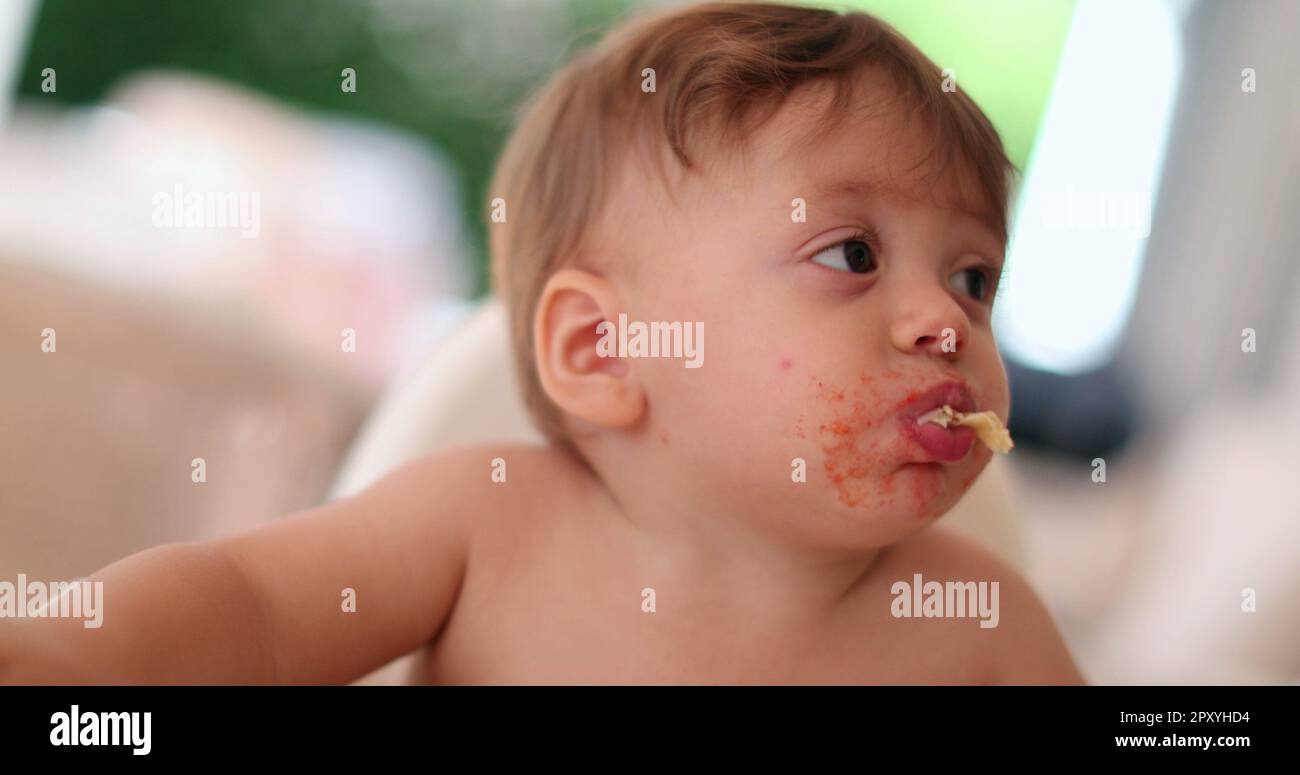 Cute baby eating and chewing with mouth full. Adorable infant toddler ...