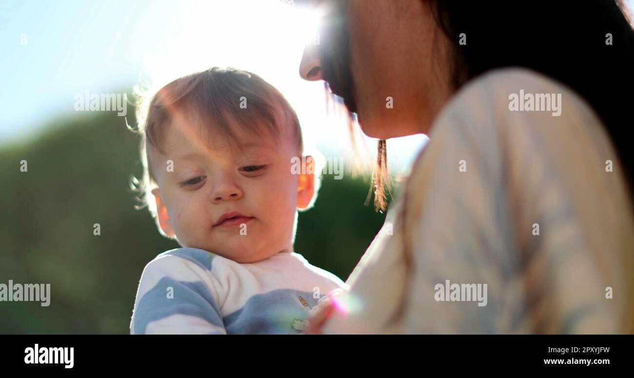 Cute baby outside in sunlight nature lens-flare. Mom and toddler ...