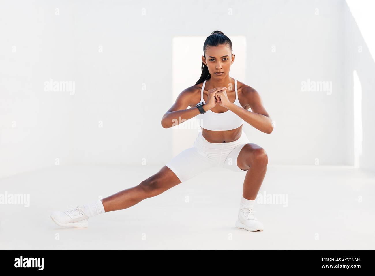 Confident fitness athlete flexing and warming up her body before an ...
