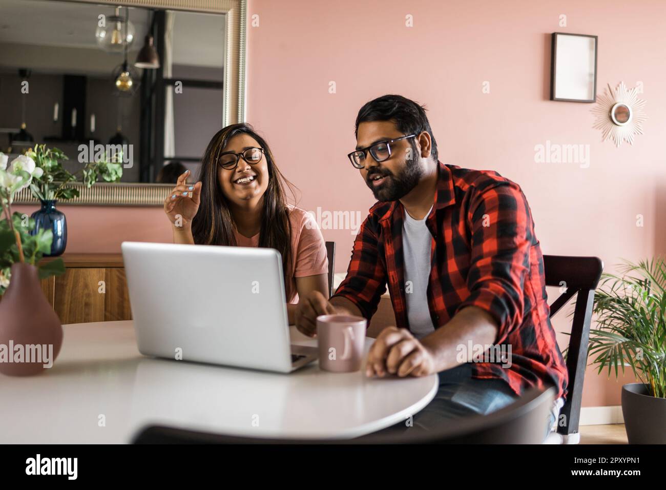 Happy indian family couple cuddle at desk make video call to friends ...