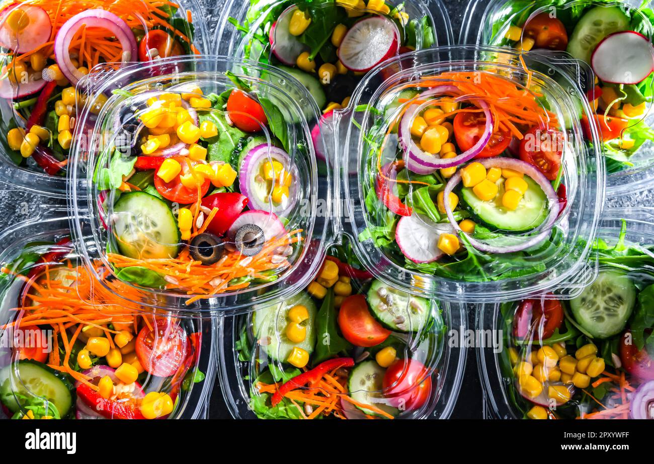 Plastic boxes with pre-packaged vegetable salads, put up for sale in a ...
