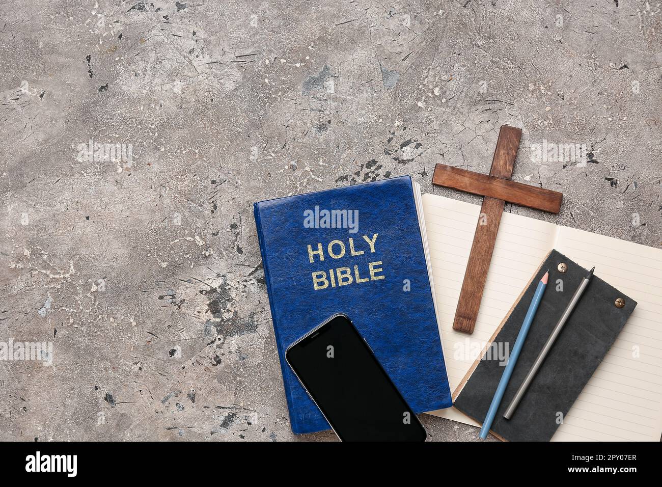 Holy Bible with mobile phone, notebooks and cross on grunge background ...