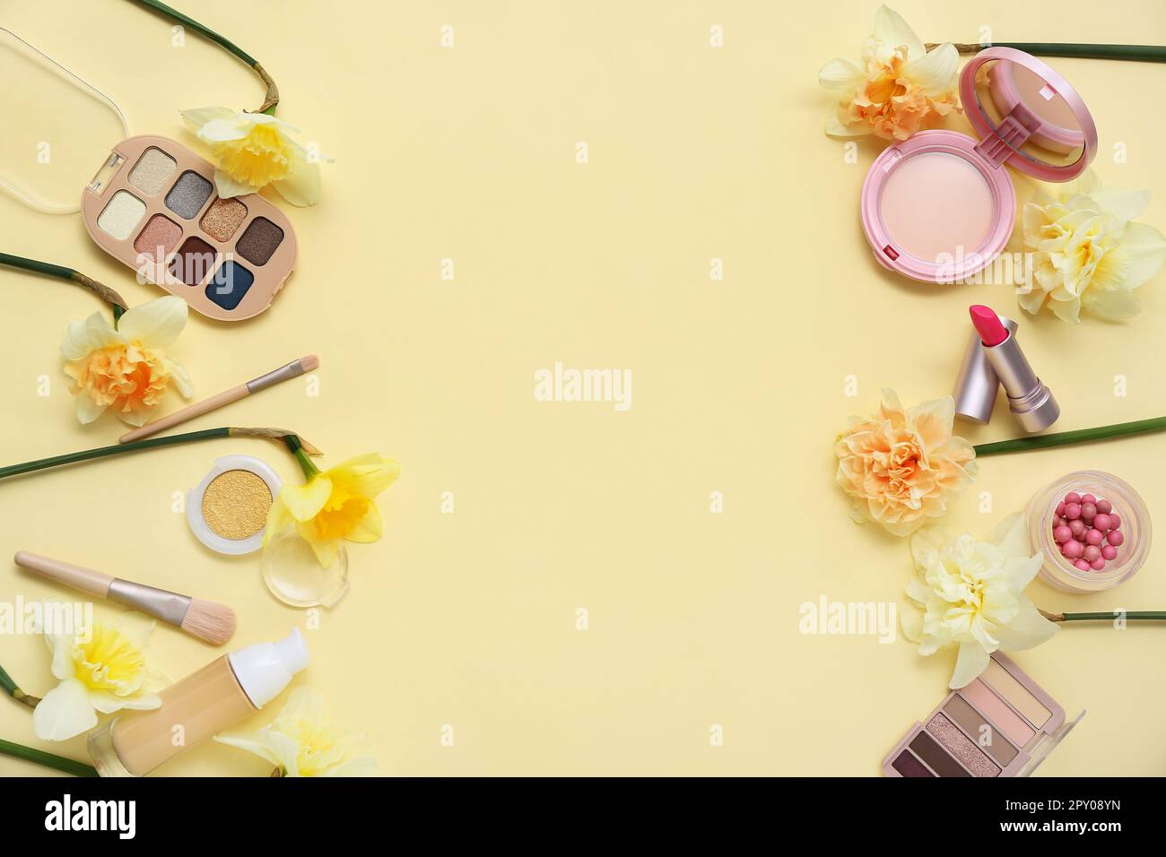 Beautiful daffodils with different cosmetics on pale yellow background ...