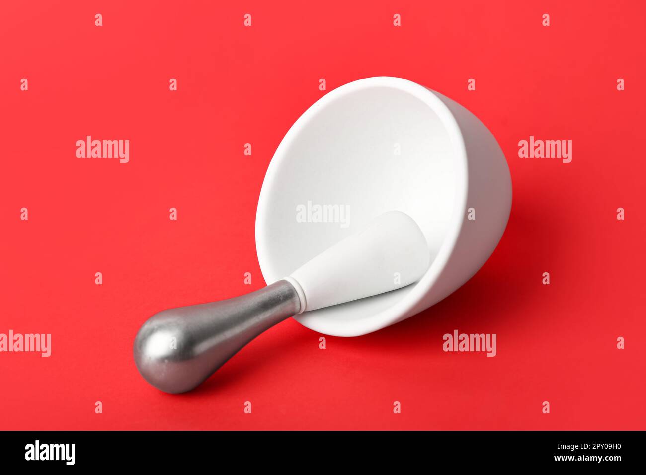 Mortar and pestle on red background Stock Photo - Alamy