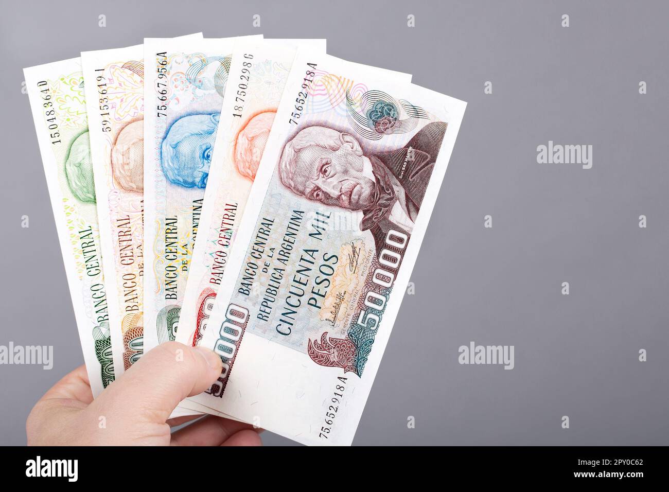 Old Argentine money - peso in the hand on a gray background Stock Photo ...