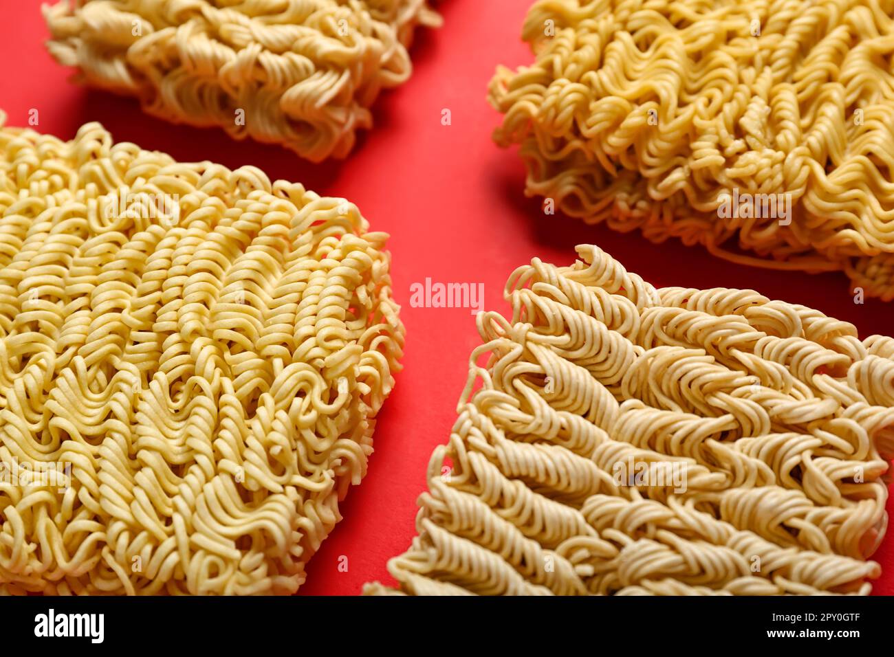 Raw instant noodles on red background Stock Photo - Alamy